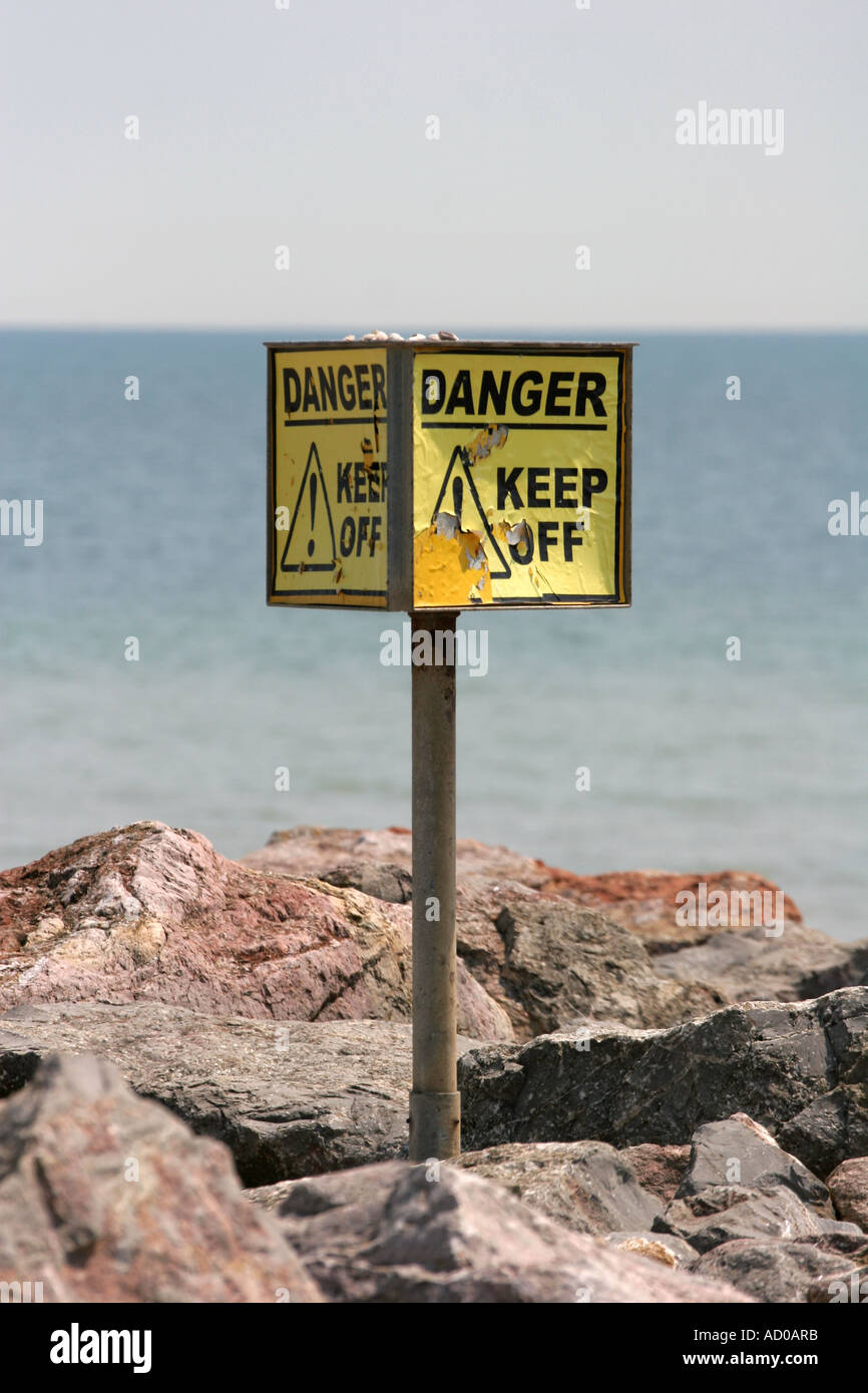 sign warning people to keep off dangerous rocks Stock Photo - Alamy