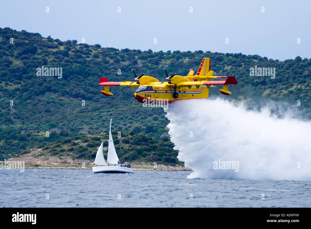 Firefighting plane releasing water near yacht Stock Photo - Alamy