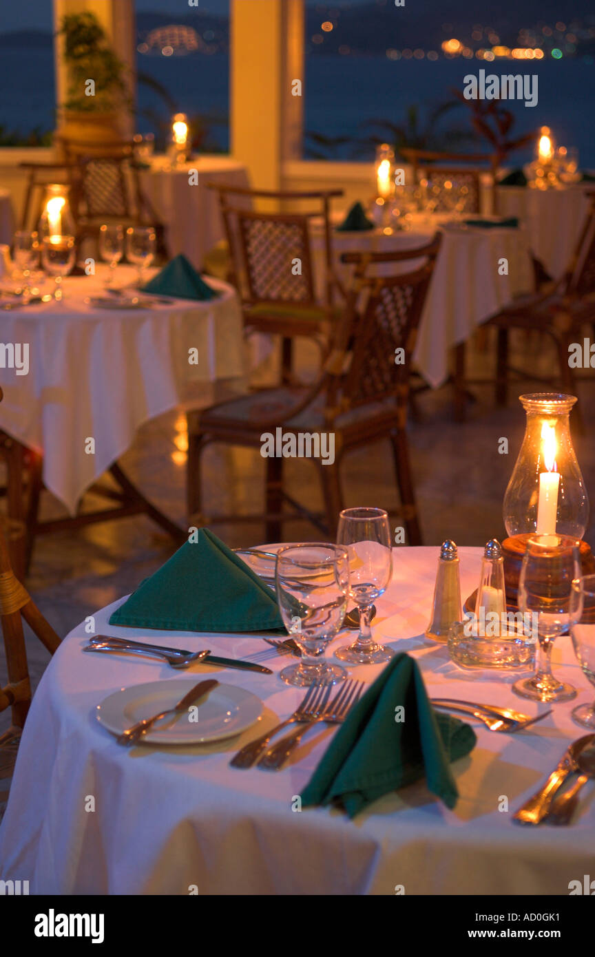 Table laid for romantic candle lit dinner service overlooking the sea ...