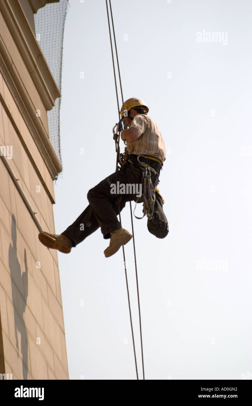 Worker abseiling down the front of Sheffield City Hall to fix banner to ...