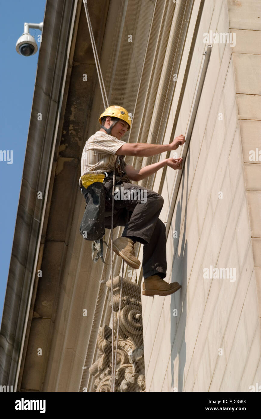 Worker abseiling down the front of Sheffield City Hall to fix banner to ...