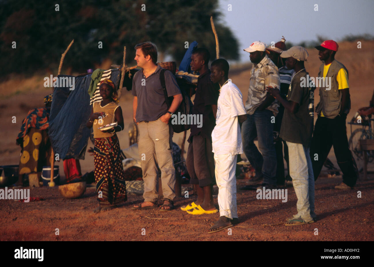 Western tourist waiting with local people for transport- Djenné, MALI ...