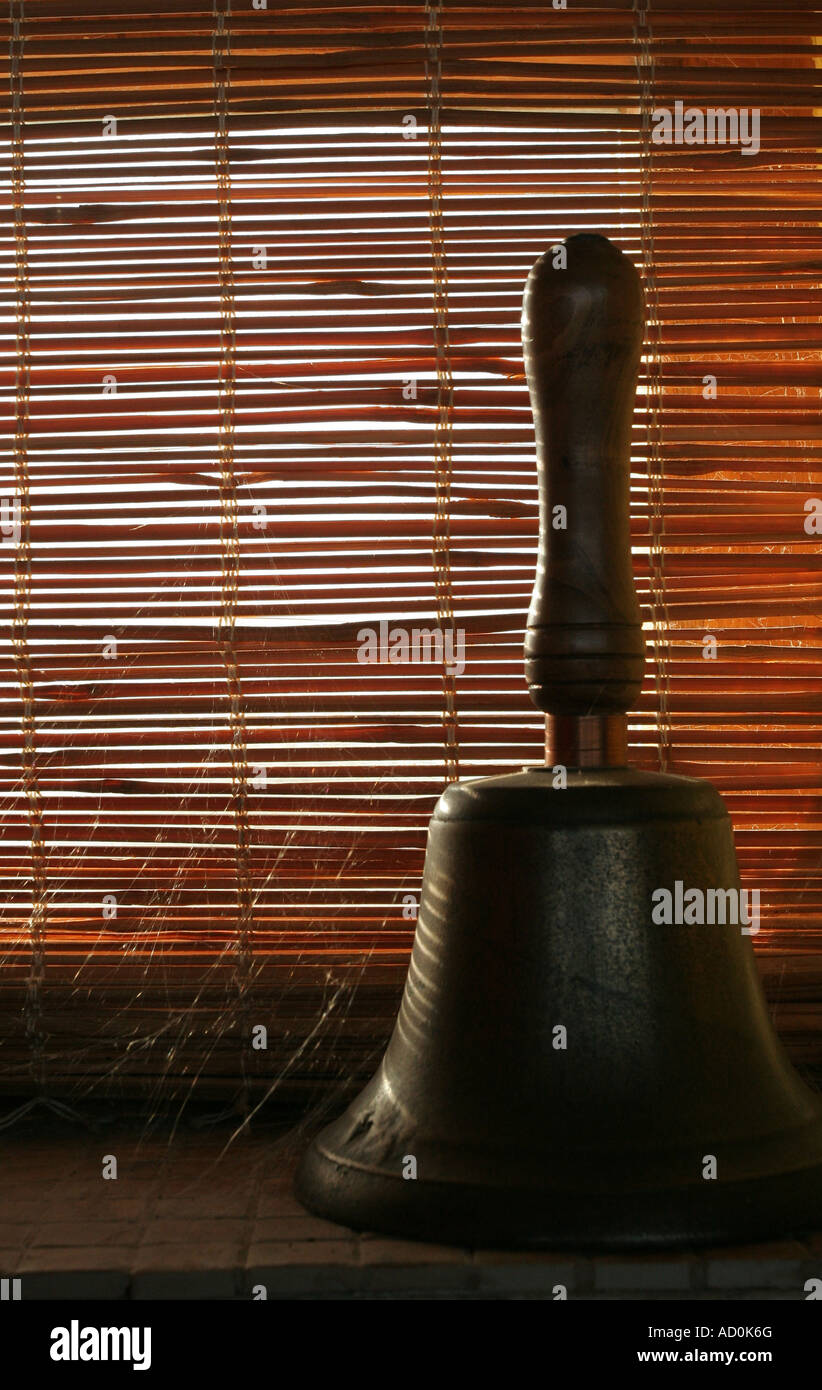 Dusty school bell on a window ledge with a wooden blind behind it Stock ...