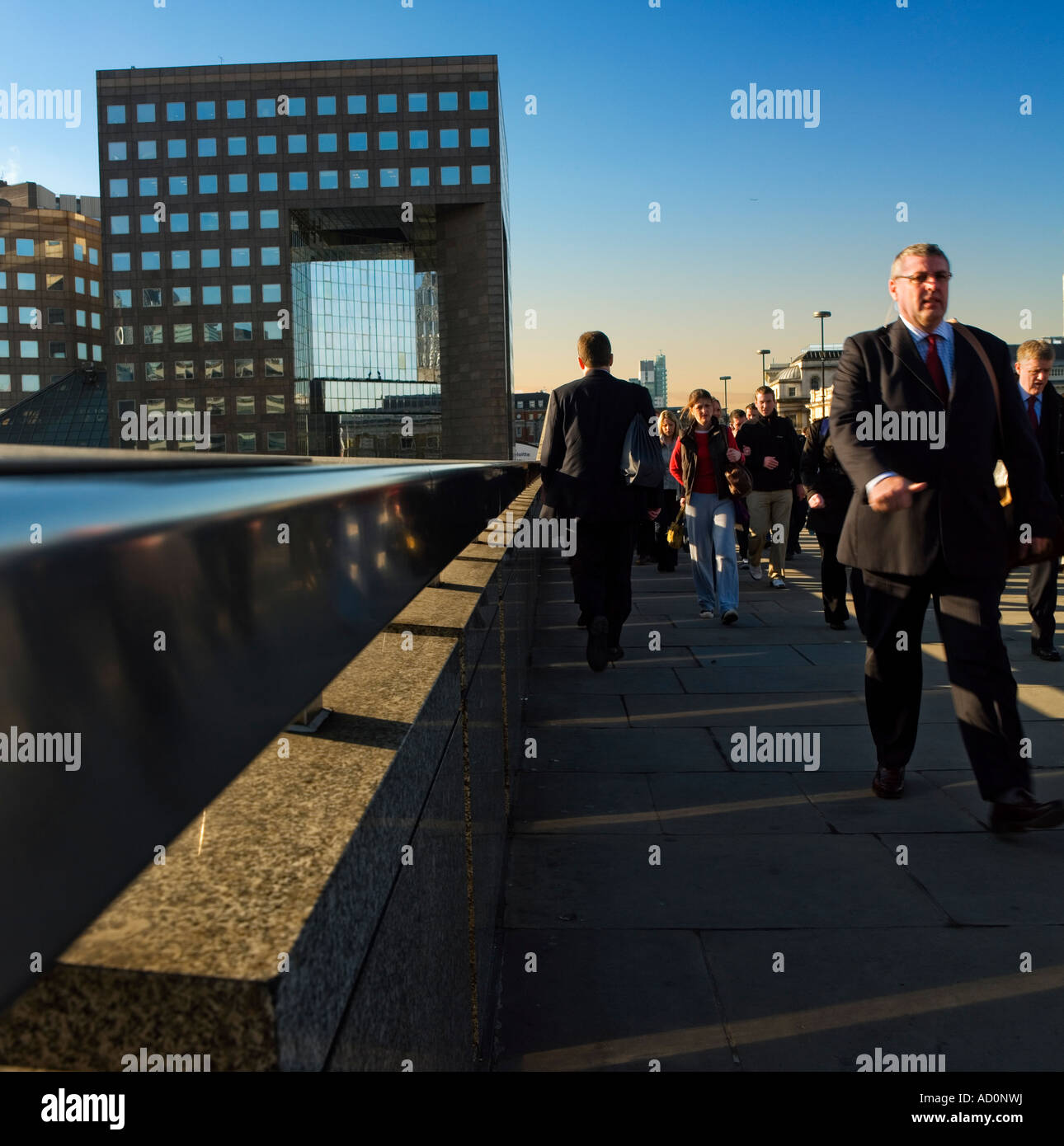 Going to work early morning office workers walking over London Bridge ...