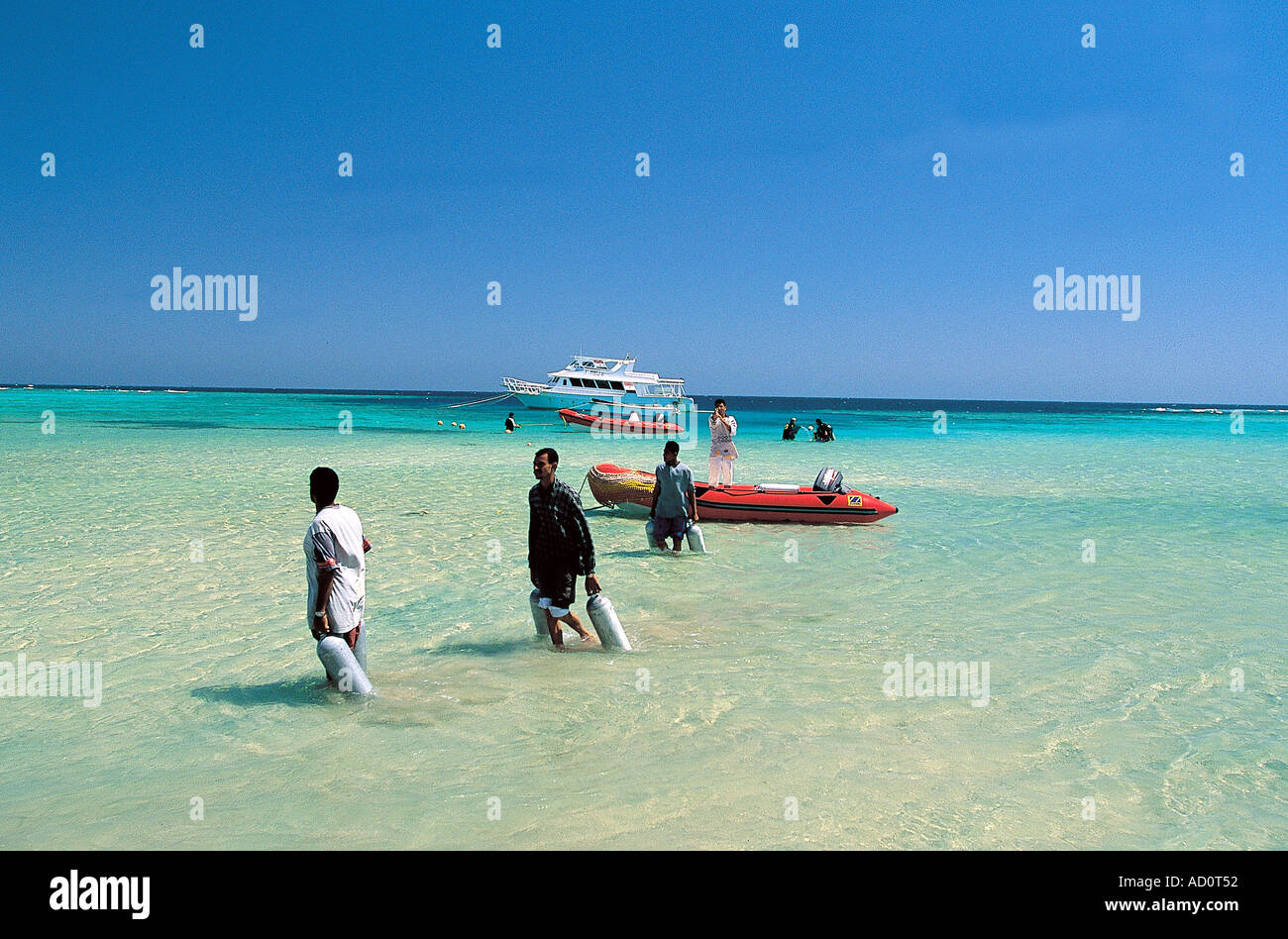 Dive crew carrying empty tanks to shore El Quesir Red Sea Egypt Stock ...