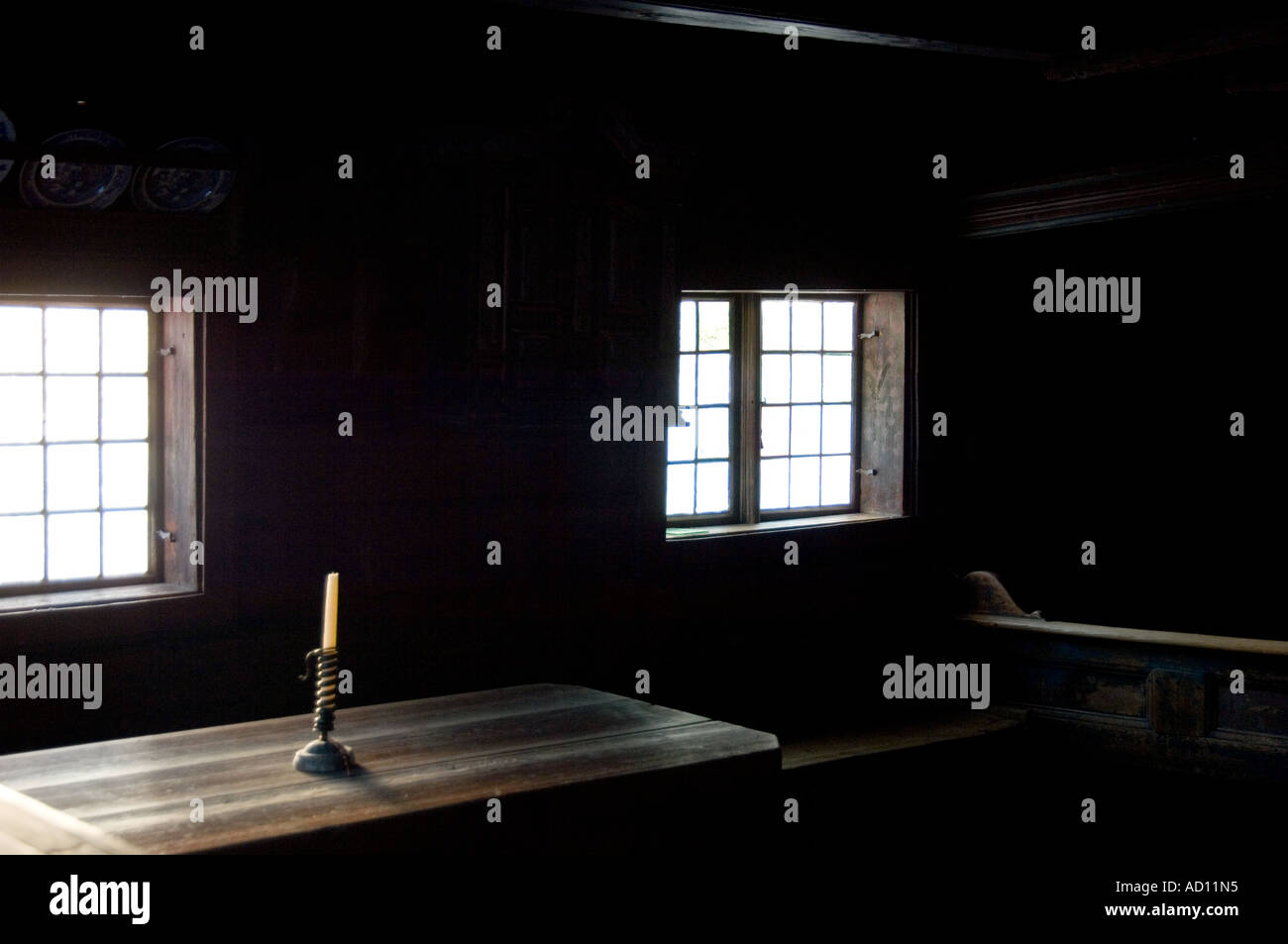 Interior of wooden house, with small-paned stained glass windows at the ...