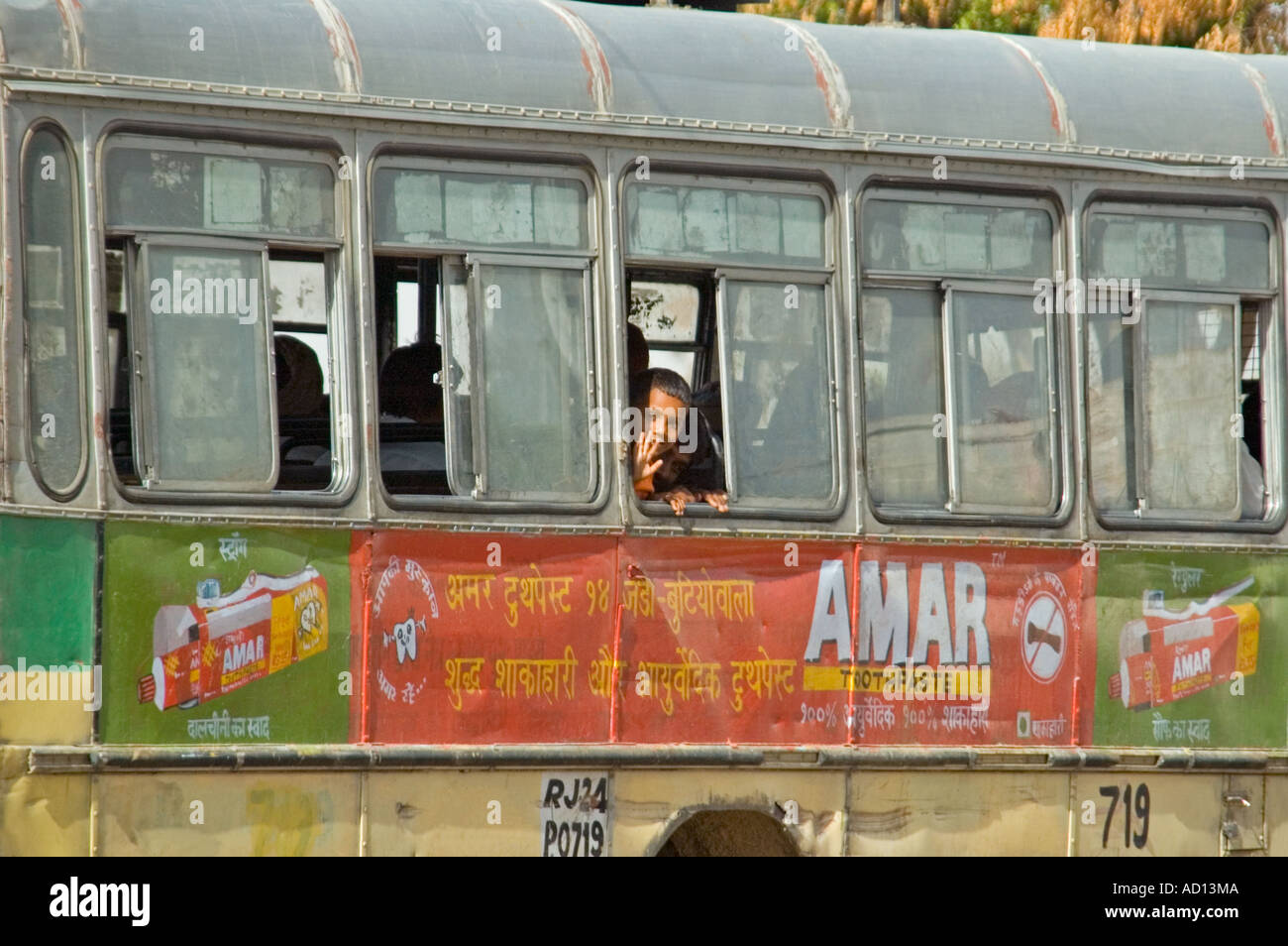 Horizontal view of a small Indian boy waving from the window of a ...