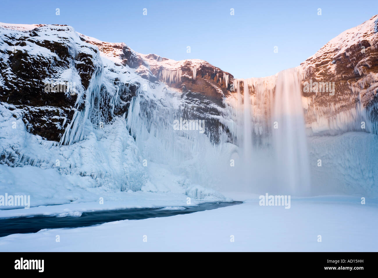 Iceland, Skogar, Skogafoss, Skogafoss waterfall surrounded by snow and ...