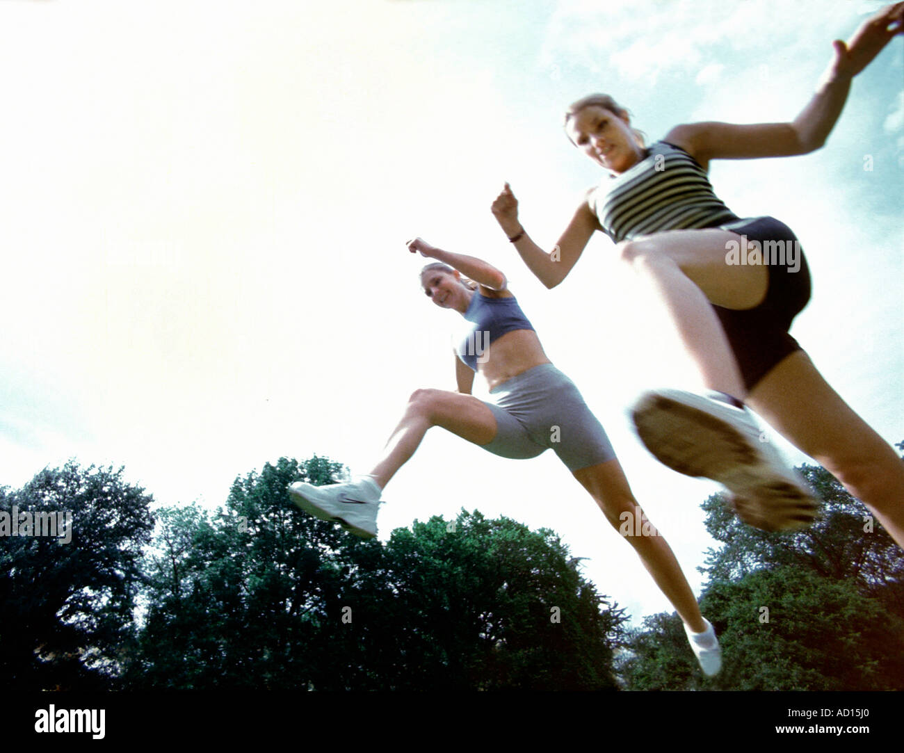 two girls jumping over Stock Photo - Alamy