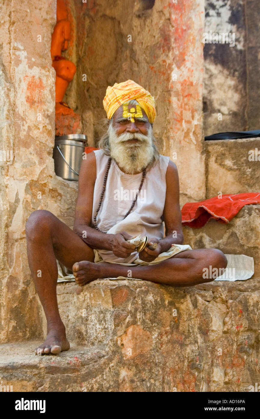 Vertical portrait of an elderly Sadhu 'holyman' with a bright yellow ...