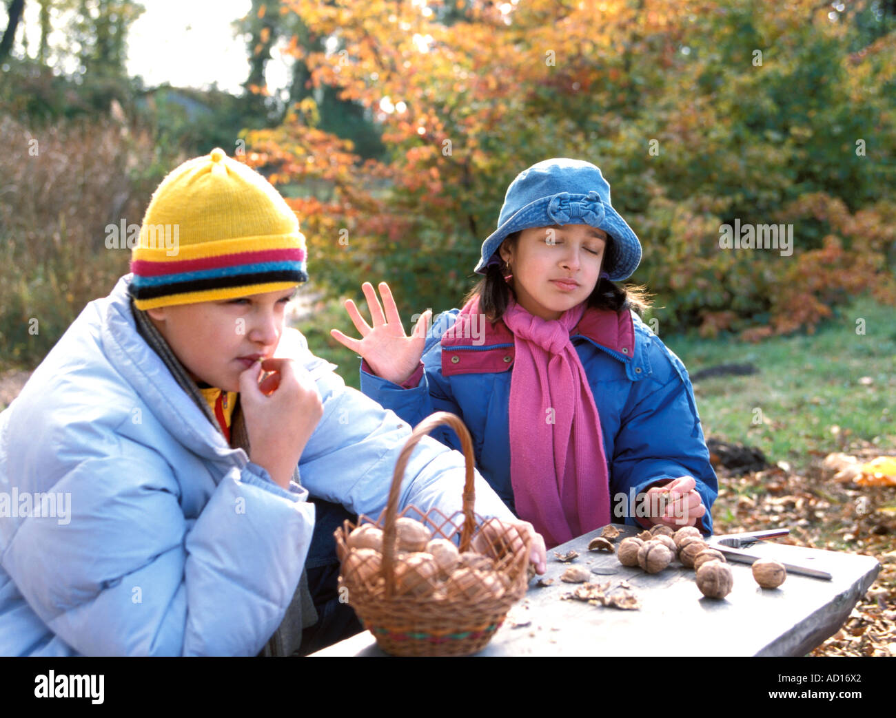 Boy and girl with nuts sitting on bench Stock Photo - Alamy