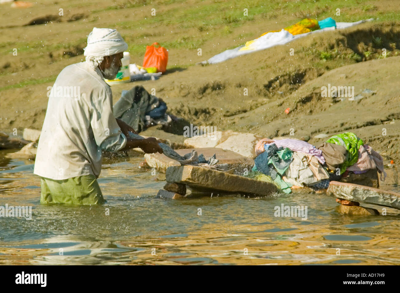 Horizontal portrait of a Indian man 'dhobi wallah' washing laundry ...