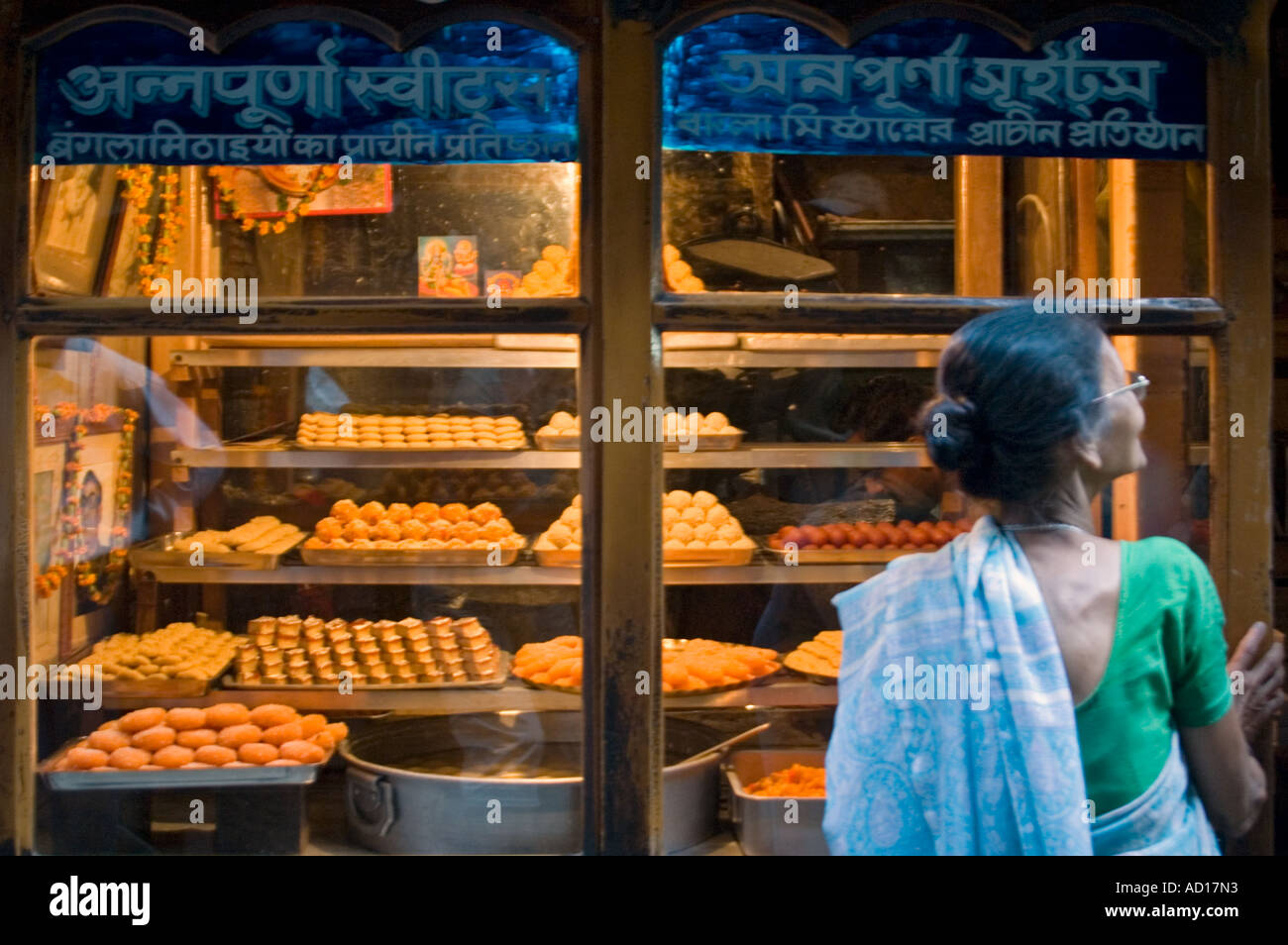 Horizontal view of two Indian ladies passing a shop window display full ...