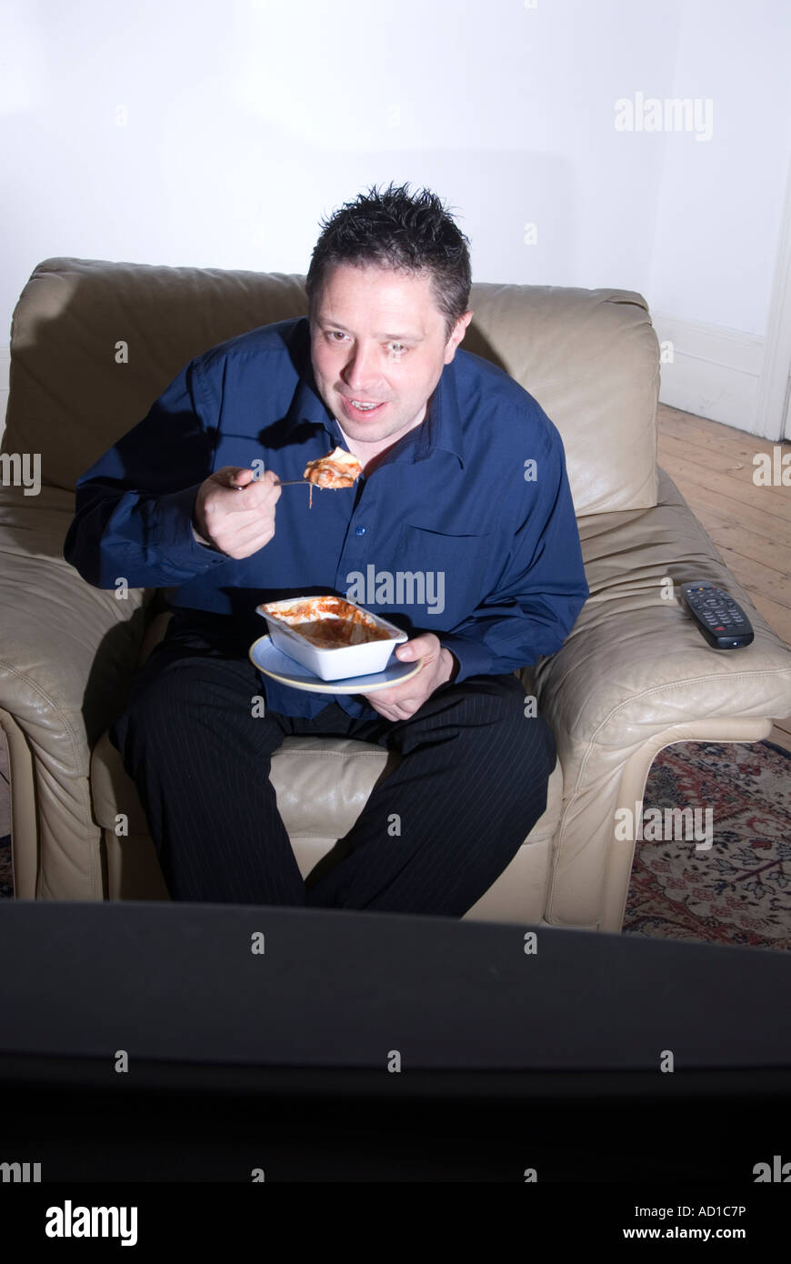 Single man eating ready meal in front of television England UK Stock ...