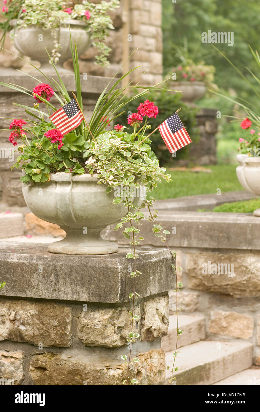 Flowers with small American flags in outdoor planter at entrance to ...