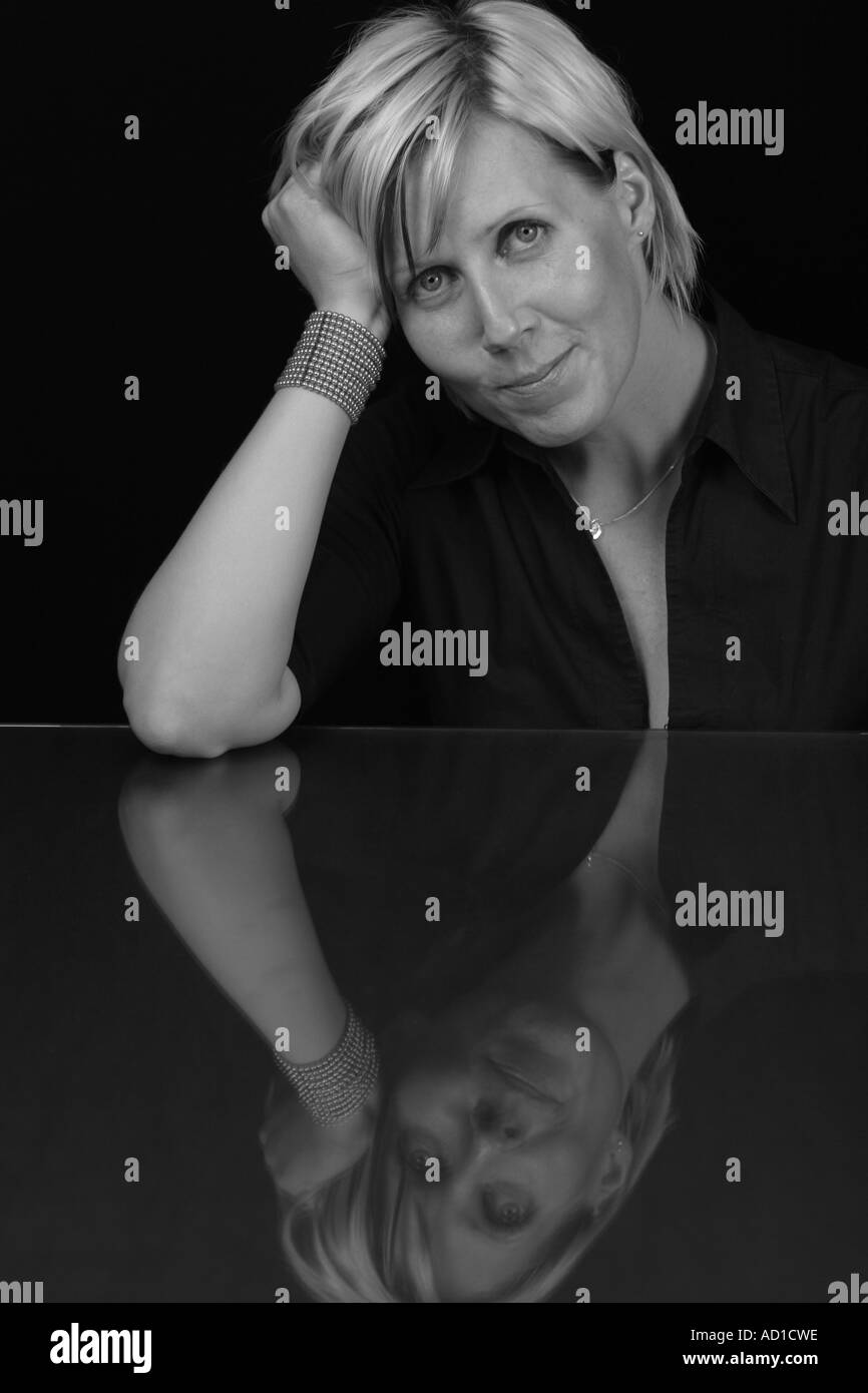 "Female model poses for shots at a glass table Stock Photo - Alamy