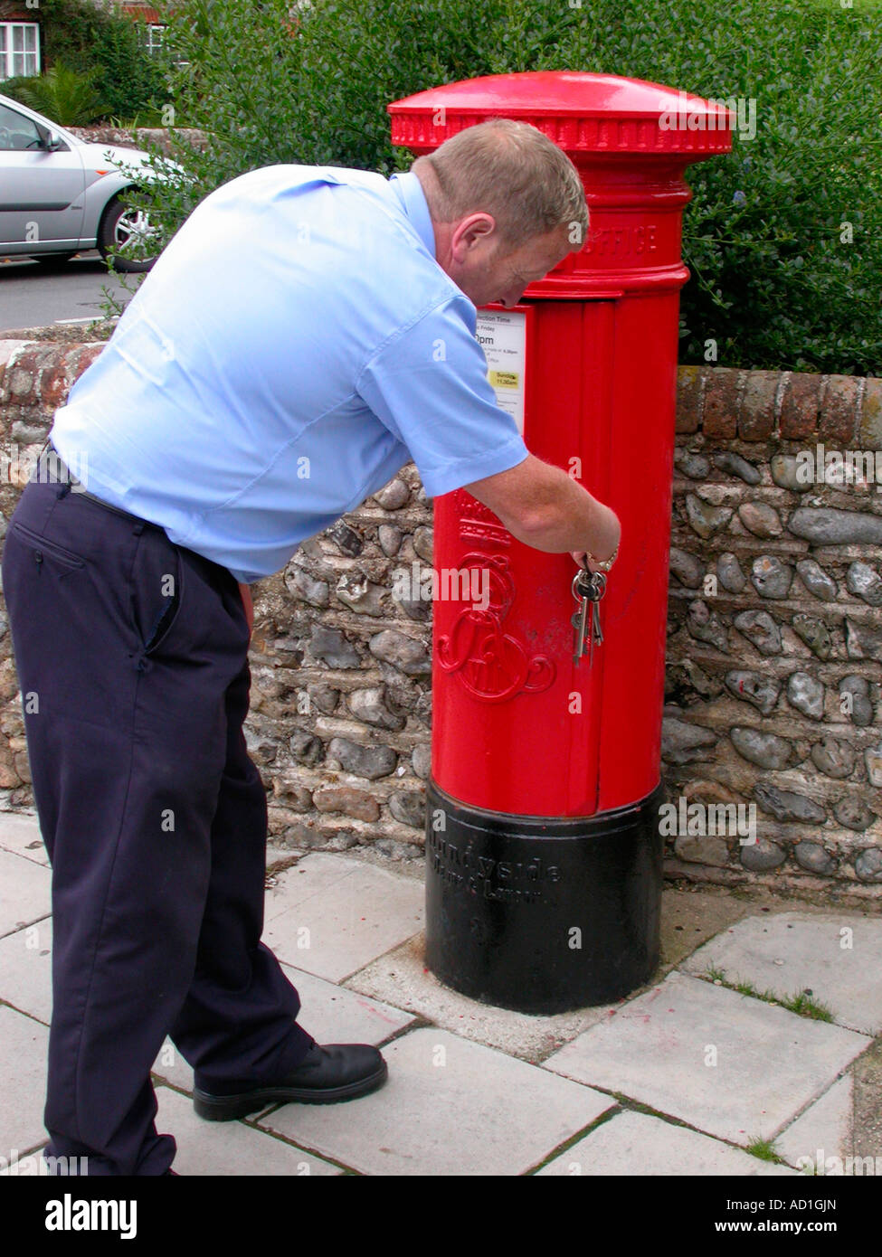 postman emptying letter box Stock Photo - Alamy
