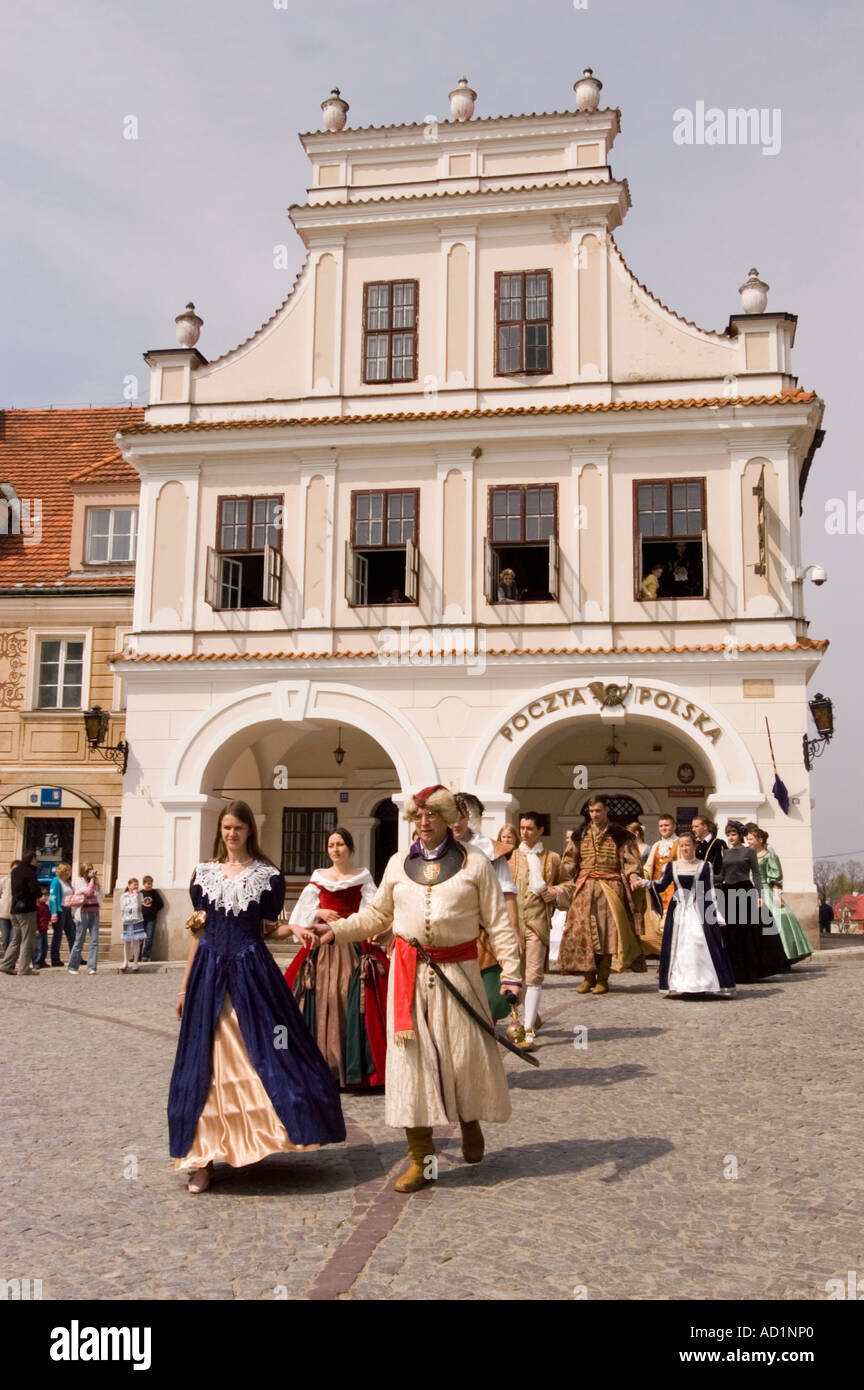 Group of courtiers in old costumes walking on Market Square Sandomierz ...