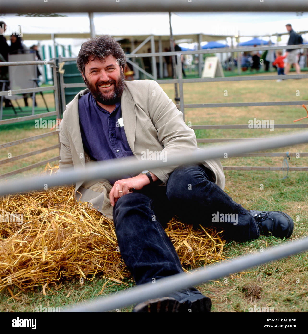 British cartoonist Steve Bell sitting in a pigpen at the Hay Festival ...