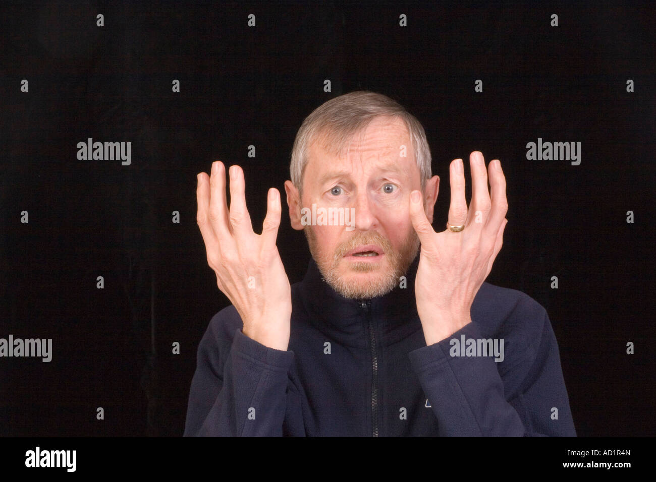 Man looking confused with hands up by his face Stock Photo - Alamy