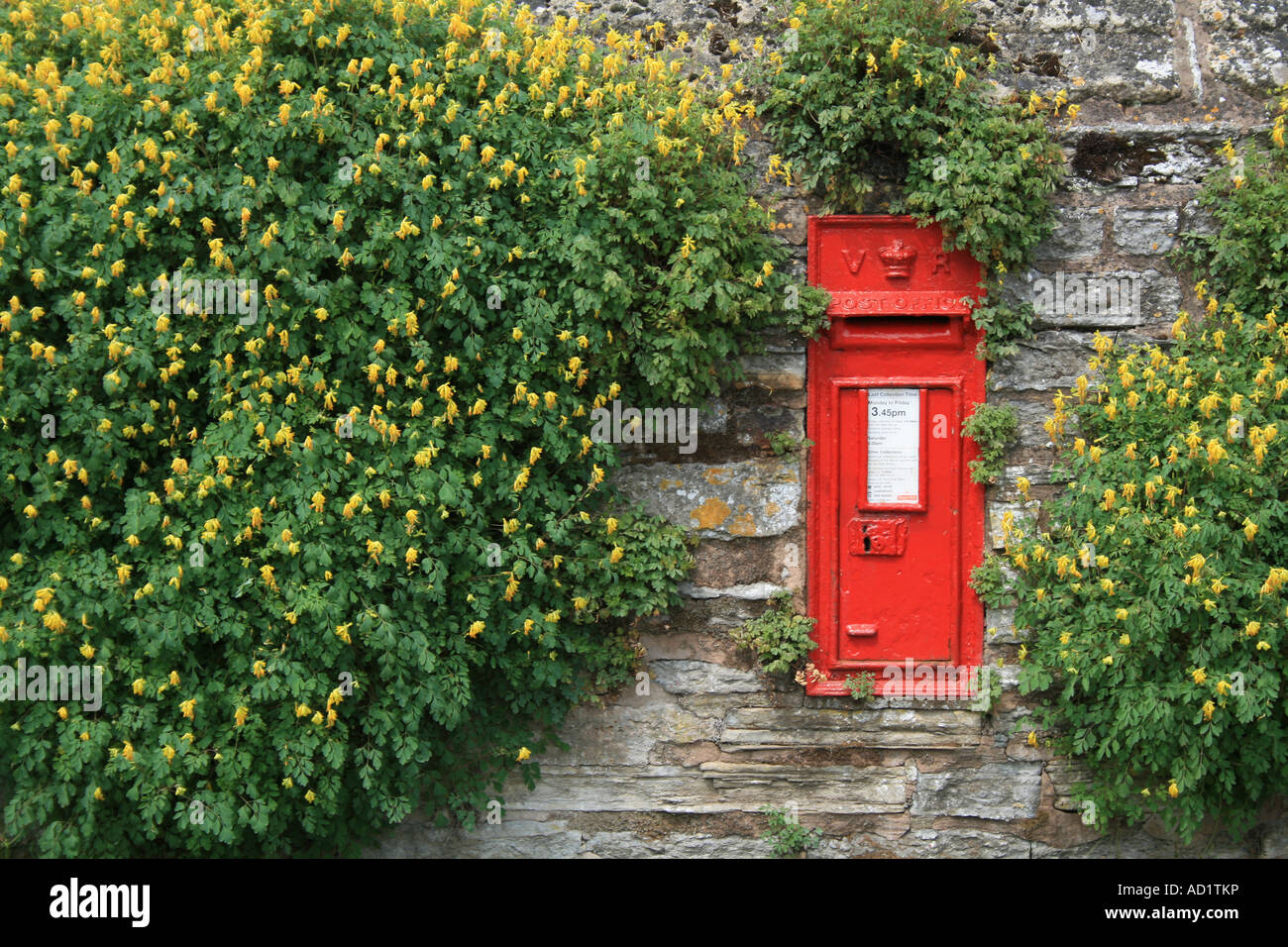 Red post box set in a stone wall Stock Photo - Alamy