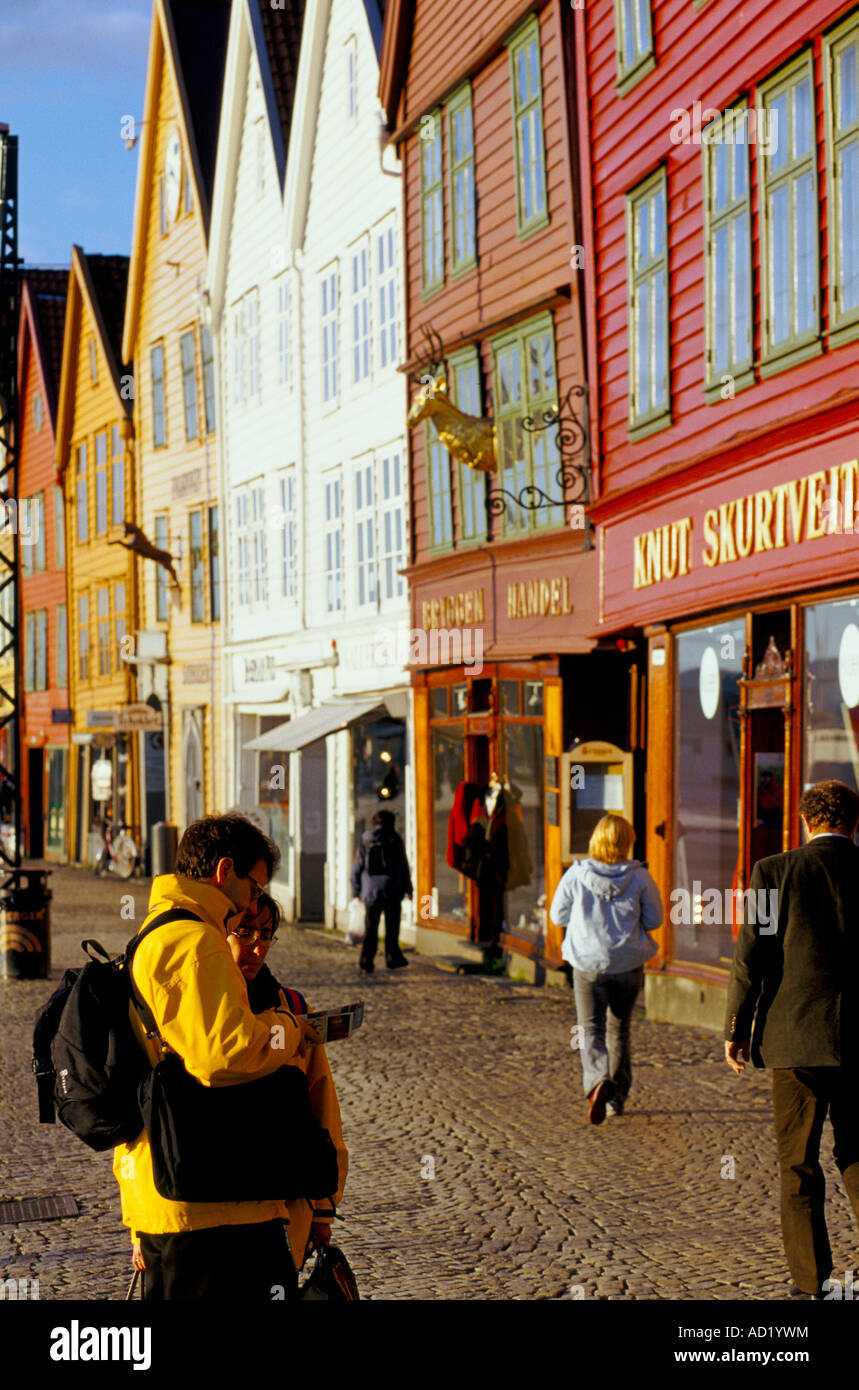 Toursits consulting a map in front of the coloured wooden houses ...
