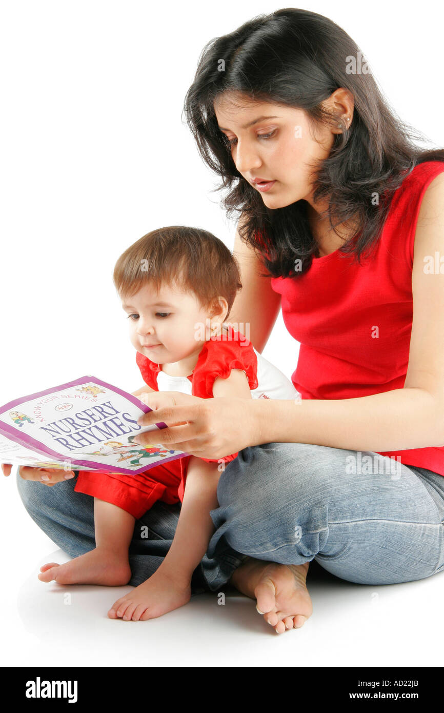 Mother teaching her child nursery rhymes from a book Stock Photo - Alamy