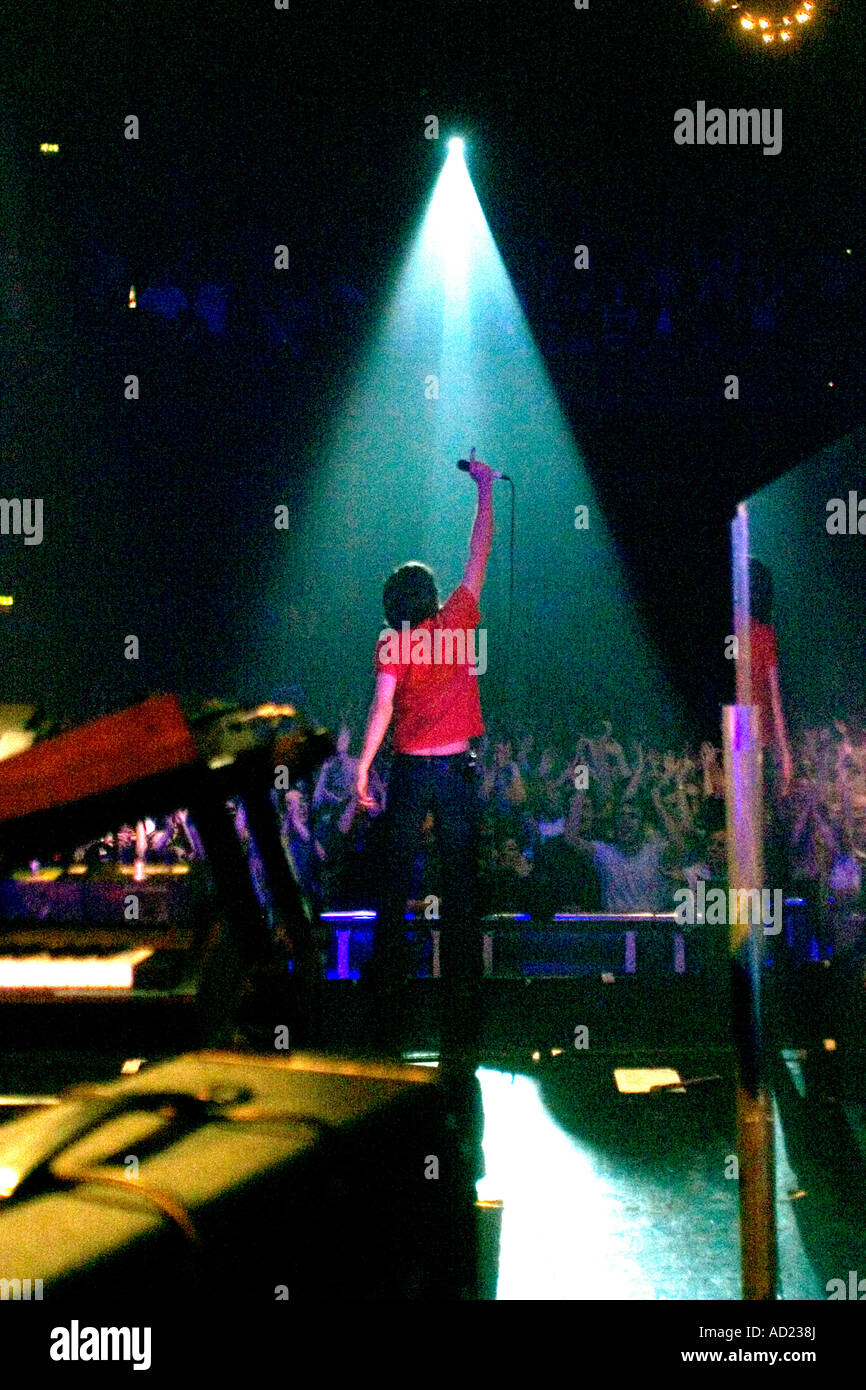 Singer on stage with spotlight Stock Photo - Alamy