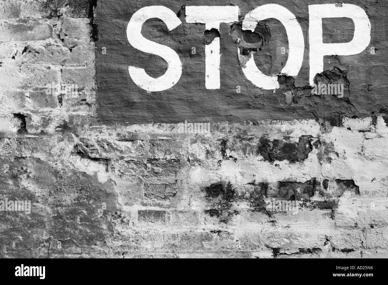 Roughly painted stop sign on a brick wall Stock Photo - Alamy