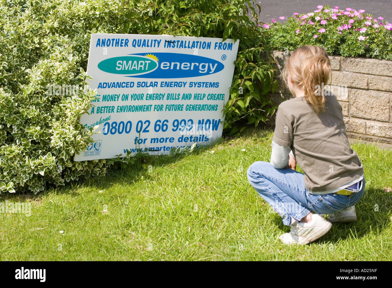 Child looking at solar energy sign outside house with newly installed ...