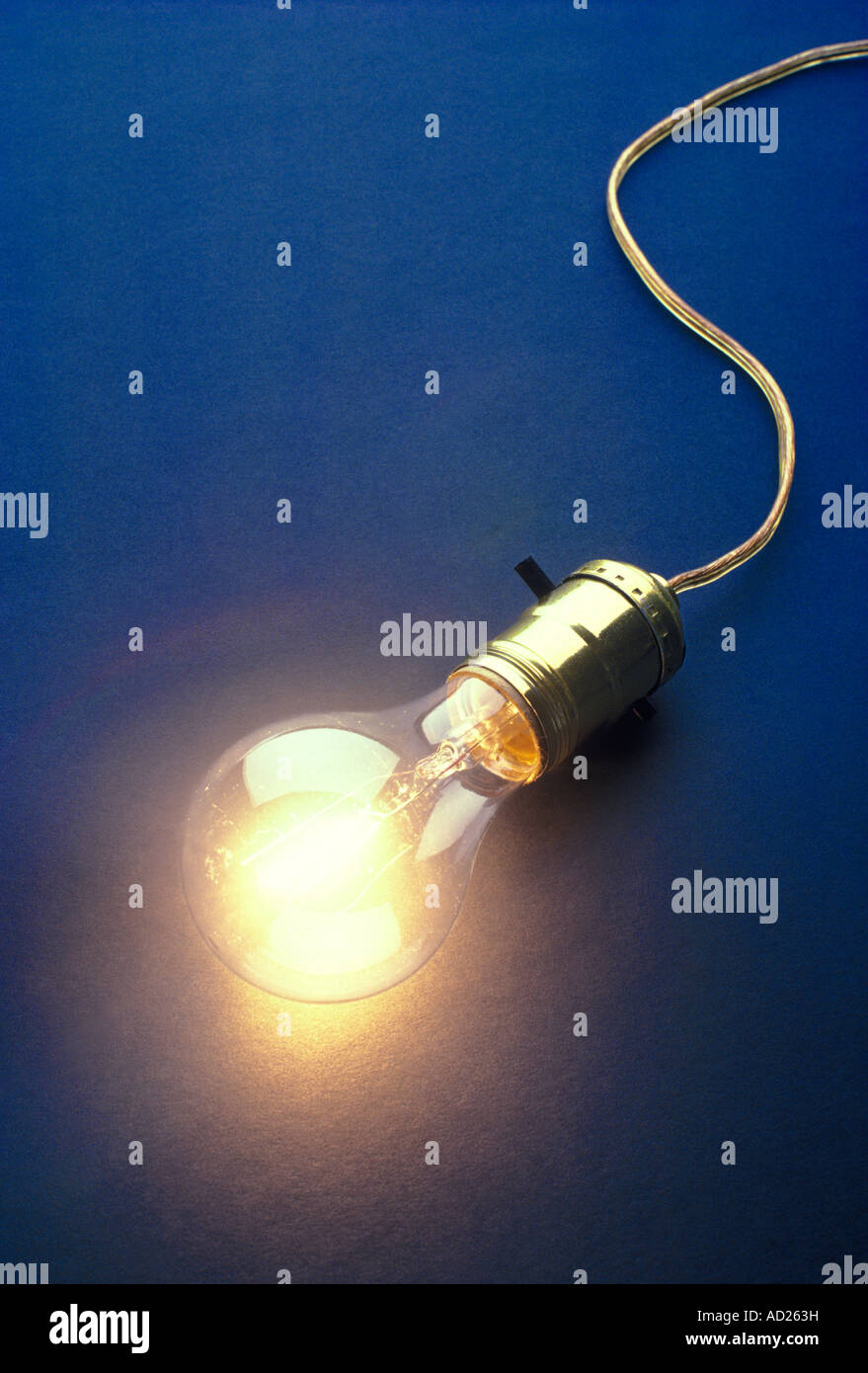 light bulb with cord laying on blue surface Stock Photo - Alamy