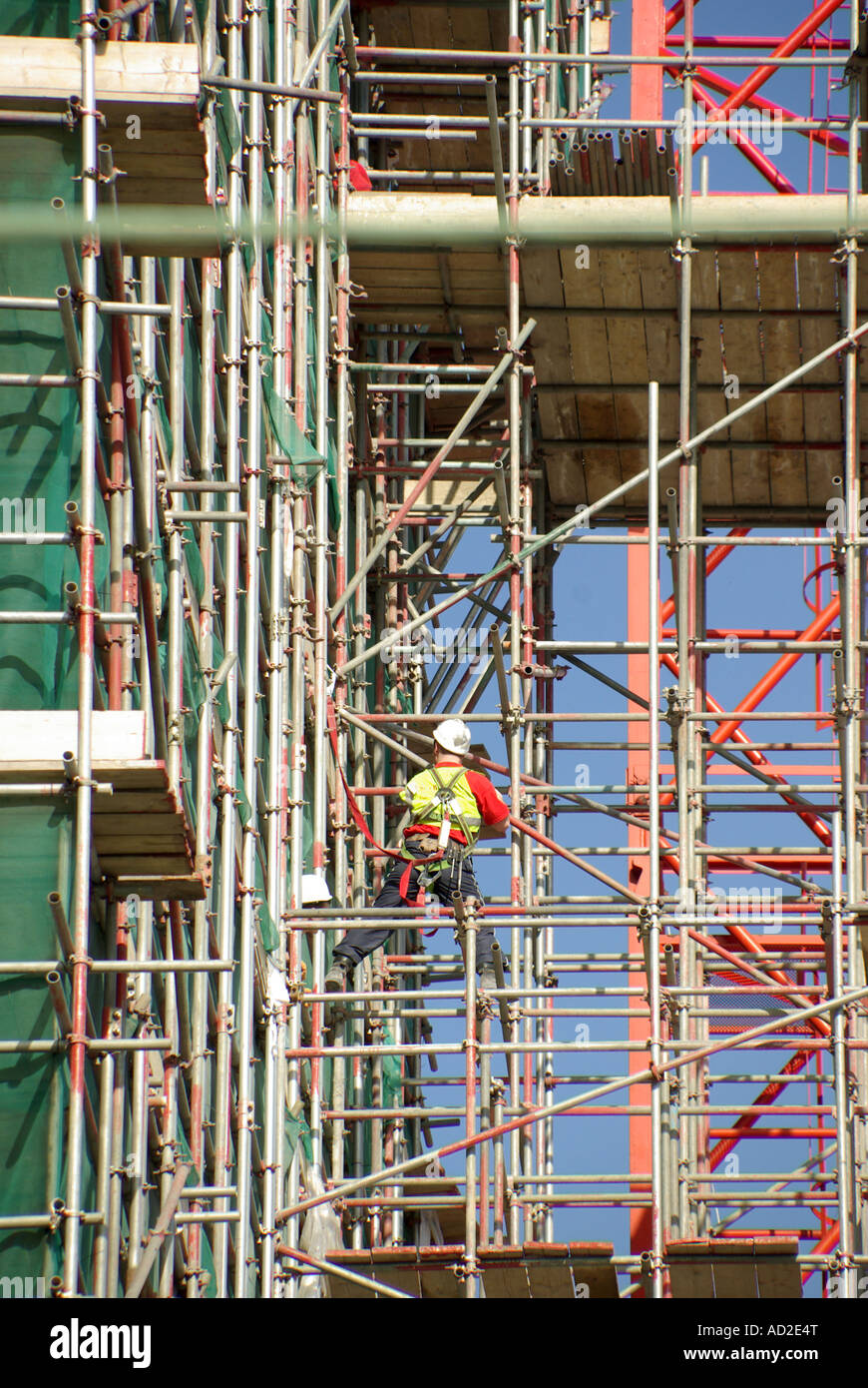 Scaffolder high vis jacket vest working on scaffold tubing construction ...