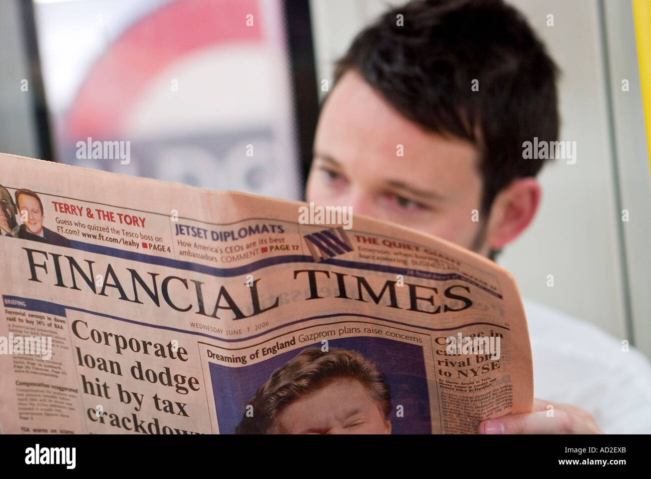 Young businessman reads Financial Times newspaper on London Underground ...