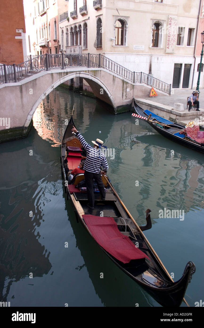 Gondolier going under bridge, Venice, Italy Stock Photo - Alamy