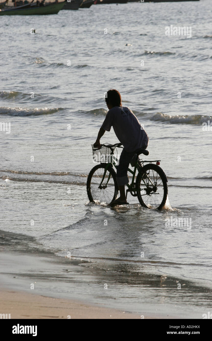 Silhouette of a young man riding a bicycle in the sea Stock Photo - Alamy