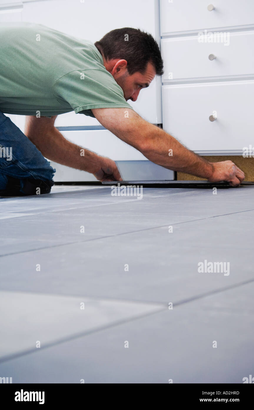 Construction workers laying tile Stock Photo - Alamy