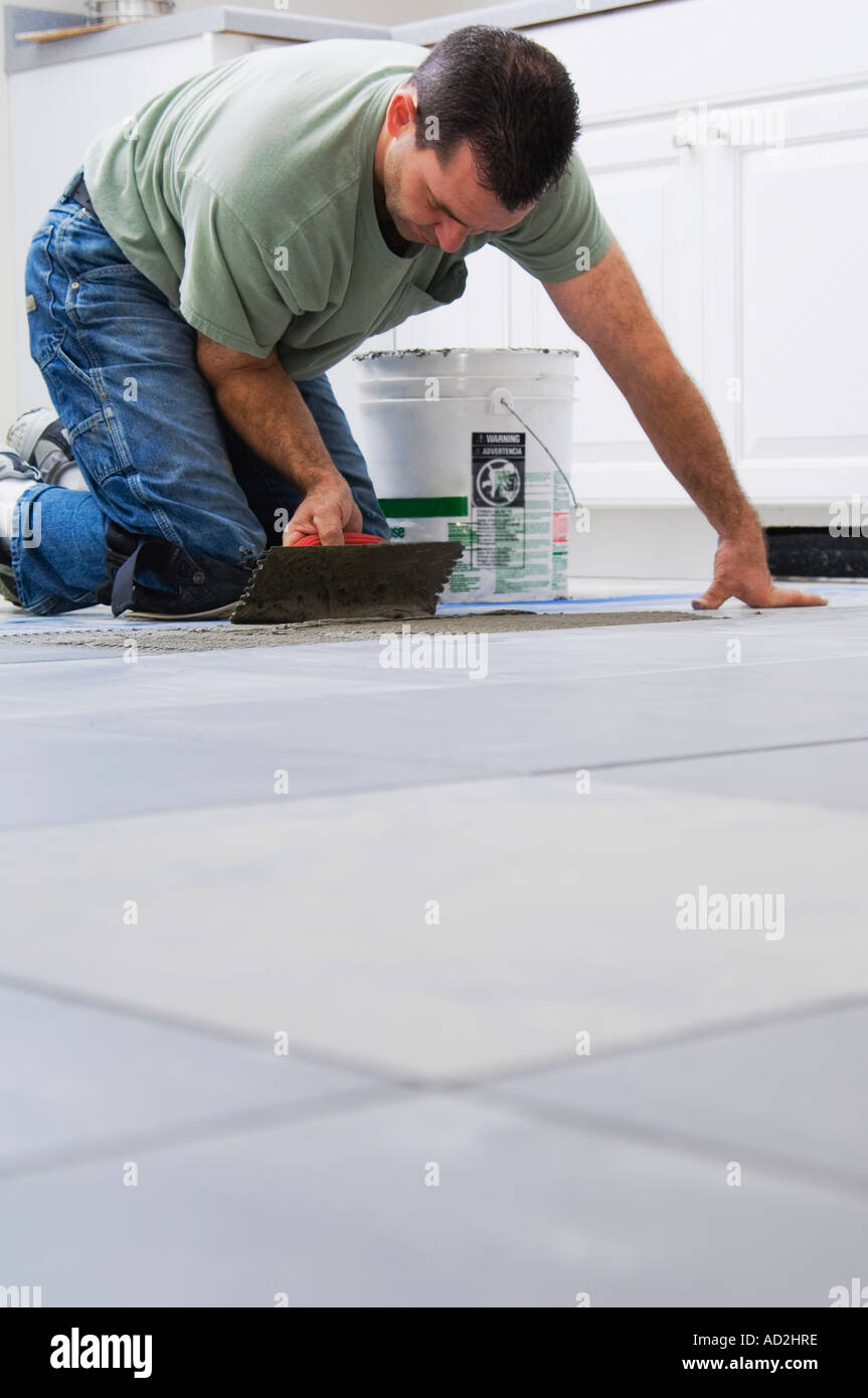 Construction worker laying tile Stock Photo - Alamy