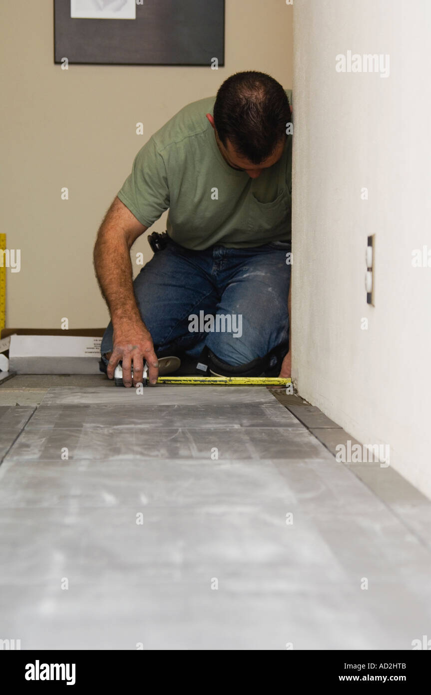 Construction worker laying tile Stock Photo - Alamy