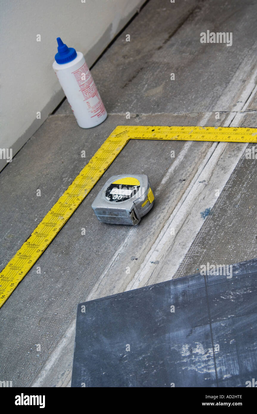 Measuring tape square and tile on subfloor Stock Photo - Alamy