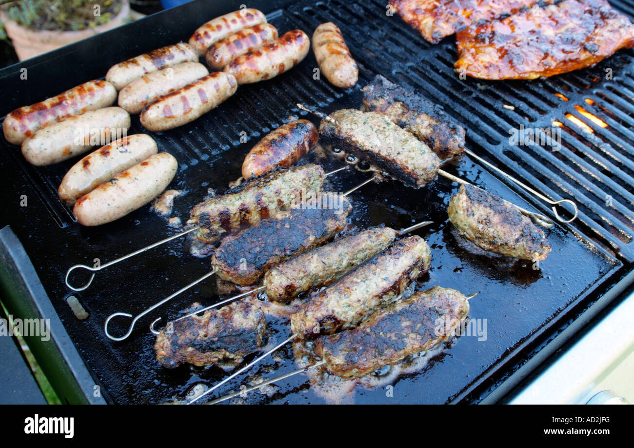 BBQ Barbecuing food Meat being cooked on a gas barbecue Pork sausages ...