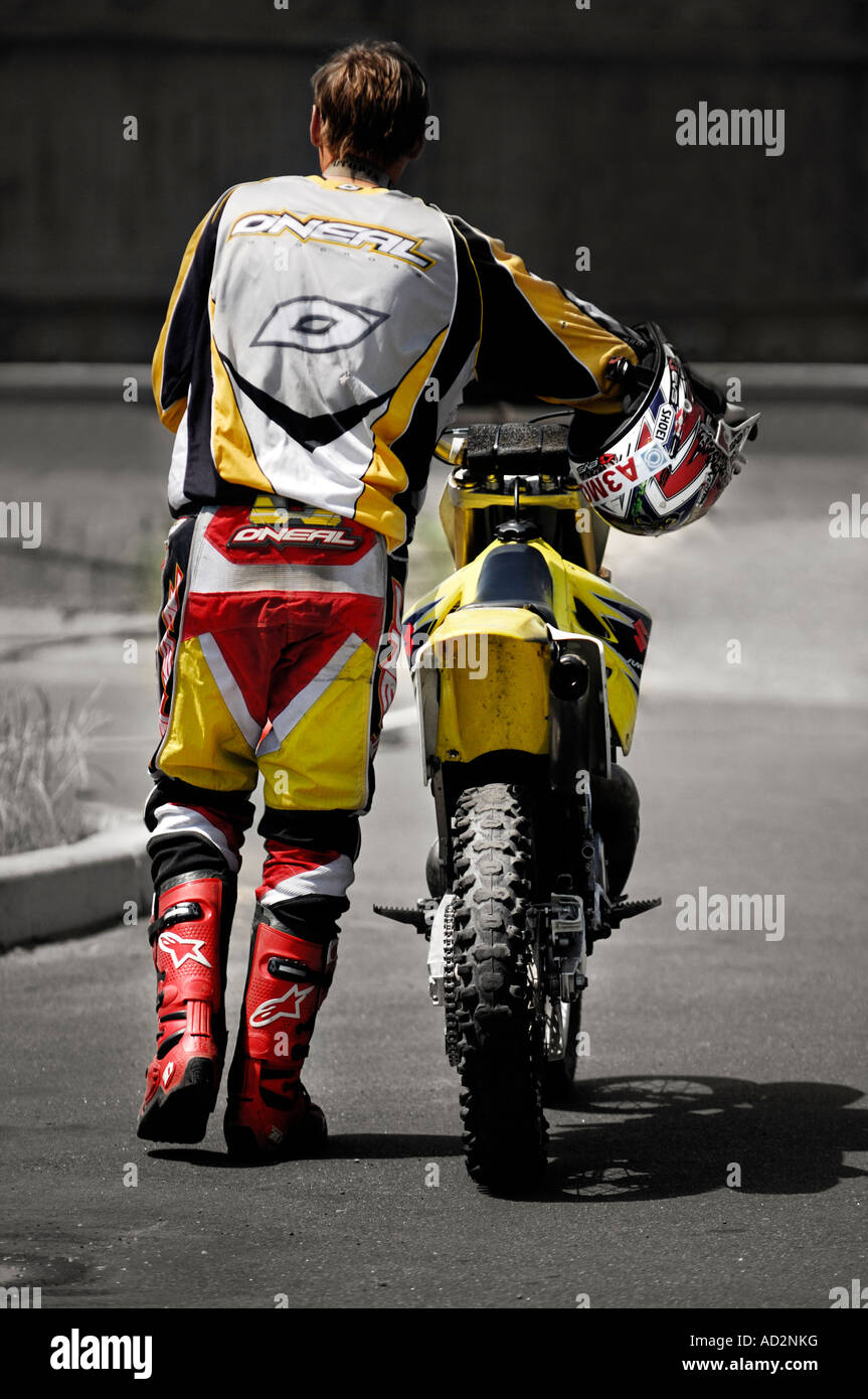 Motorcyclist walking away with a racing motorcycle Stock Photo - Alamy