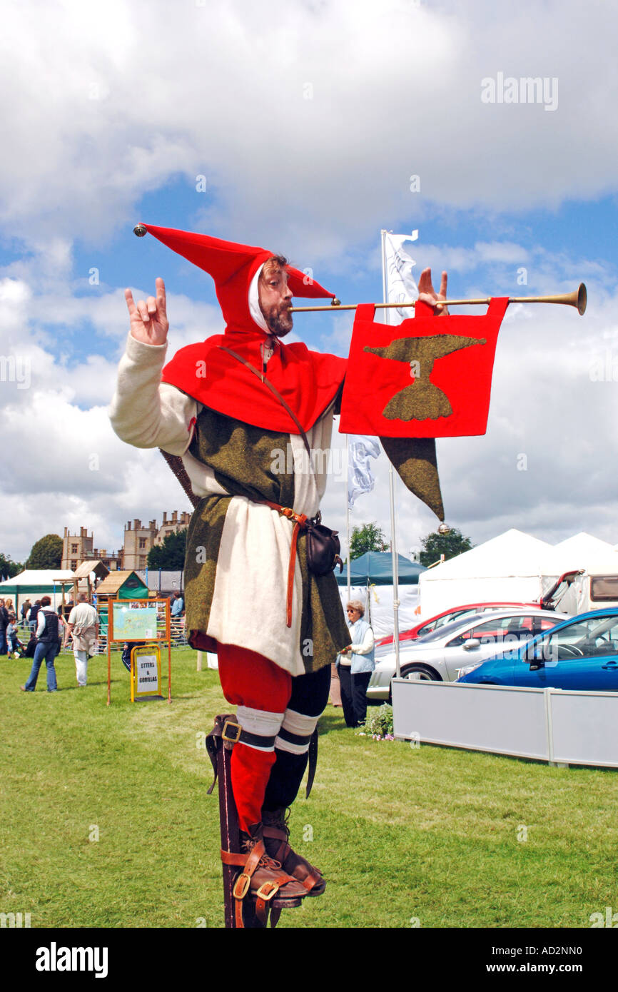 An adult male in a Jester costume walking on stilts Stock Photo - Alamy