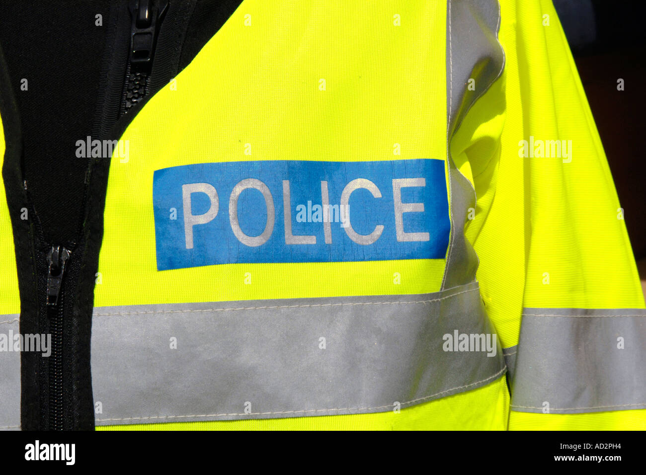 Close up of the Police sign on a yellow jacket worn by British Police ...