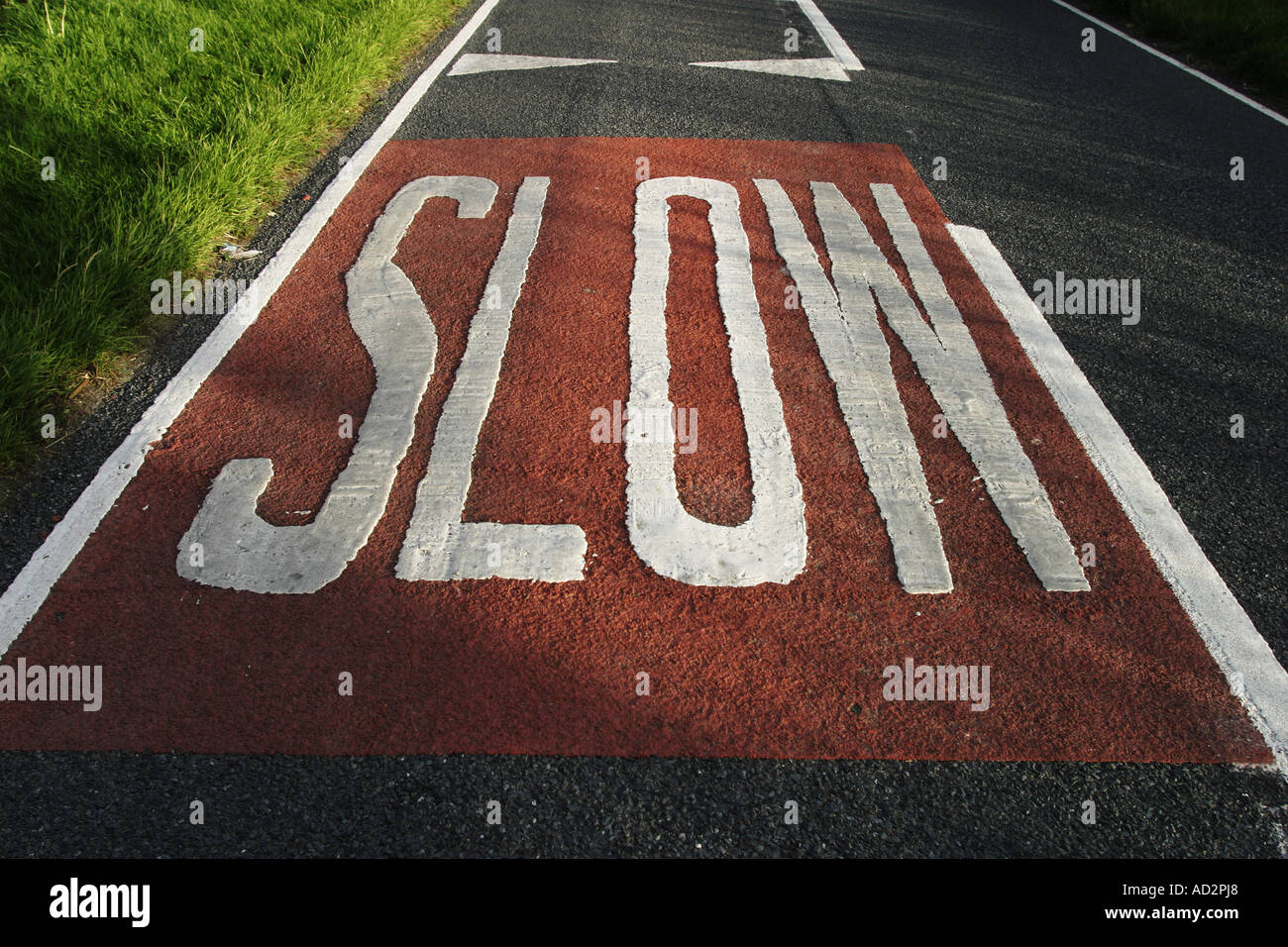 Slow sign painted on a road Stock Photo - Alamy