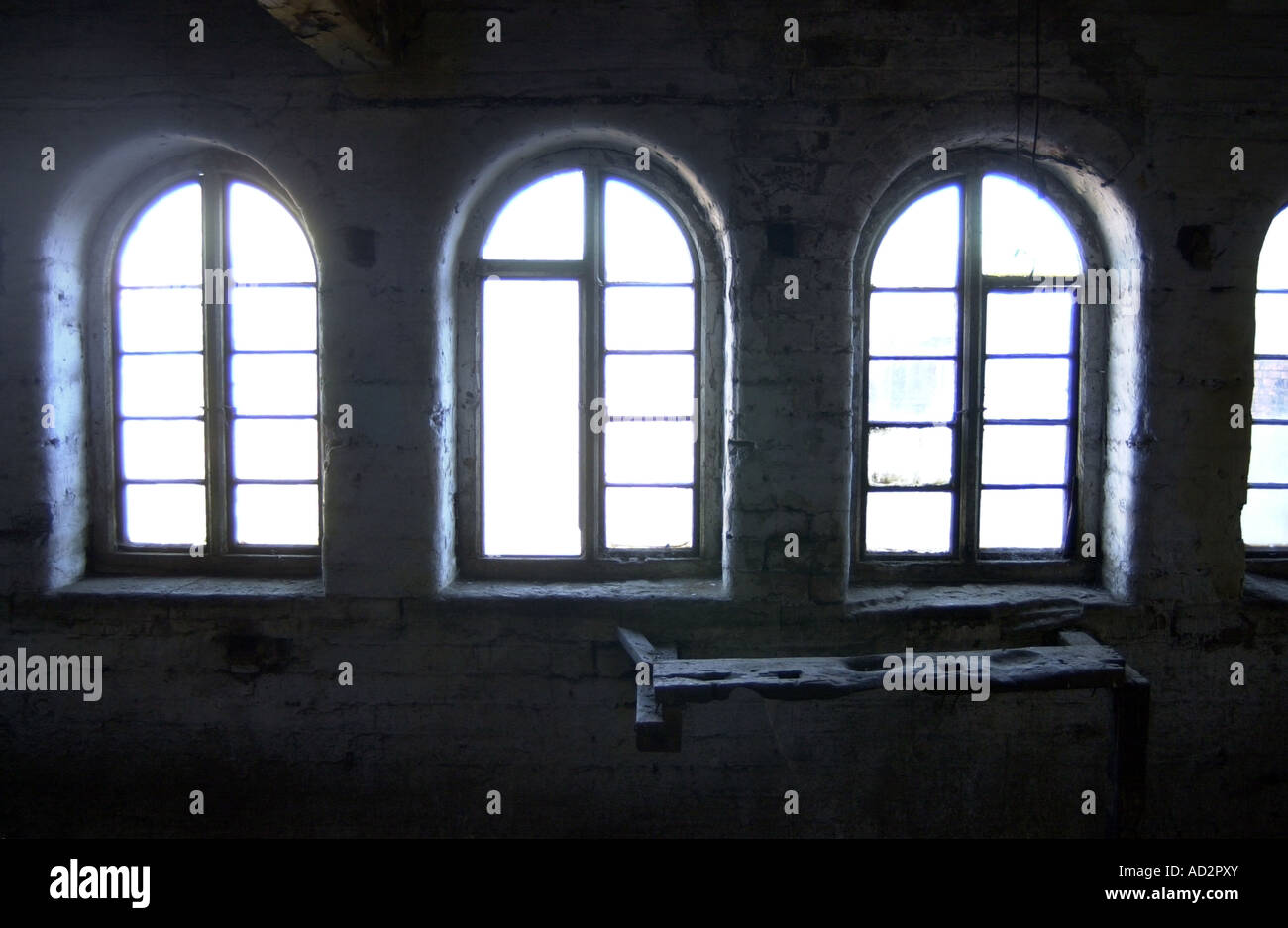 Victorian factory windows with light flooding into darkened work room ...