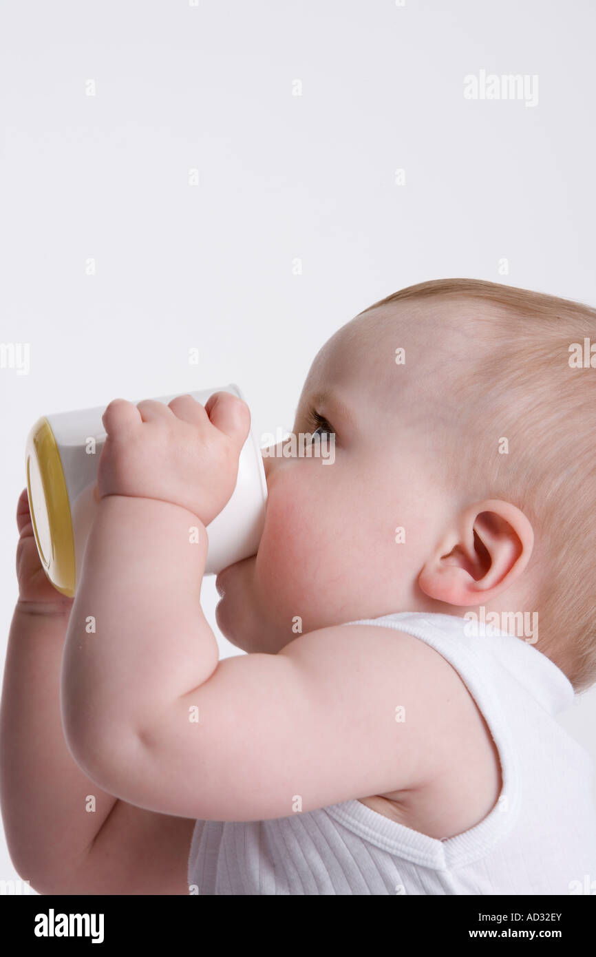 Baby boy drinking from a baby cup himself Stock Photo - Alamy
