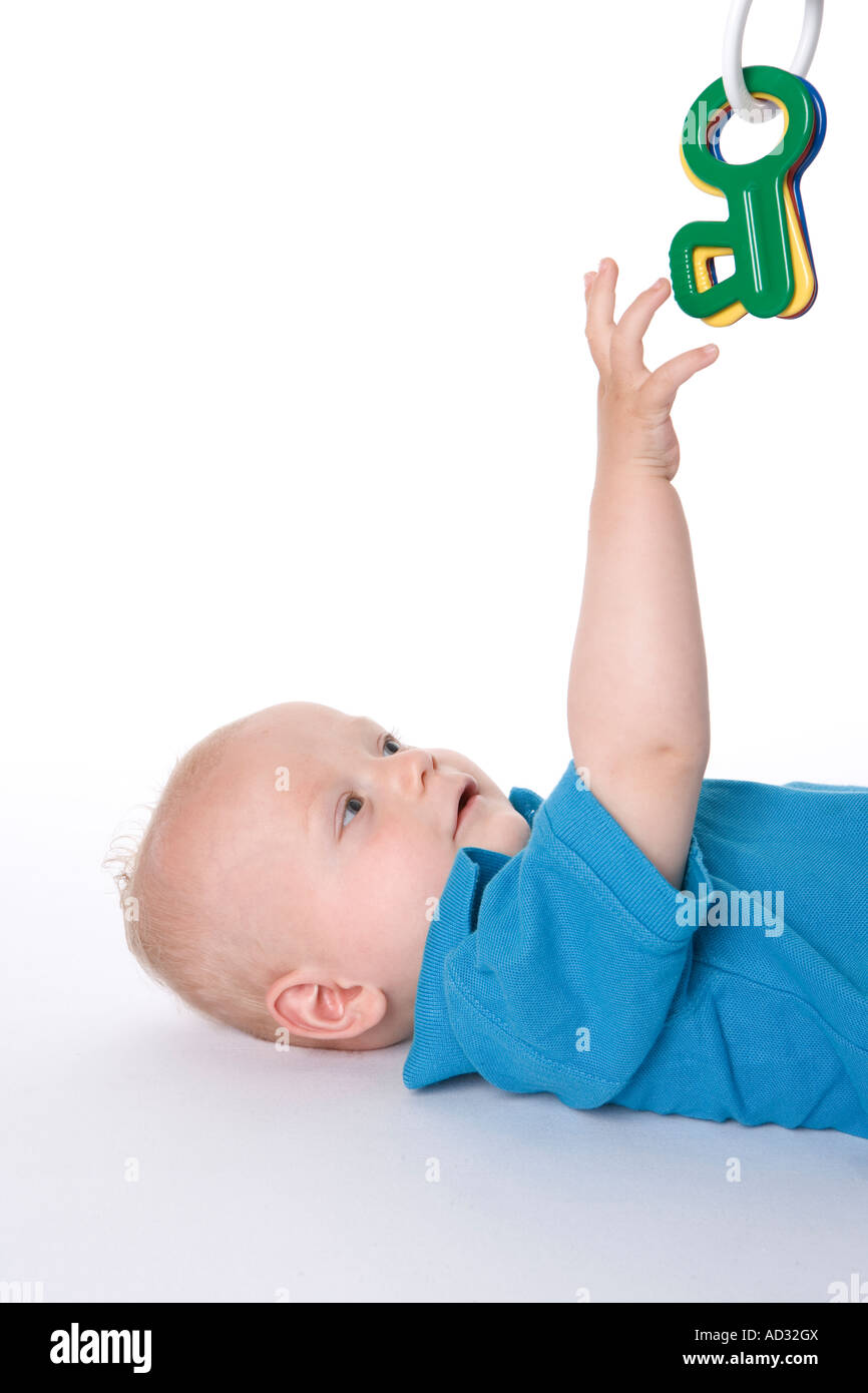 Little boy reaching for a toy Stock Photo - Alamy