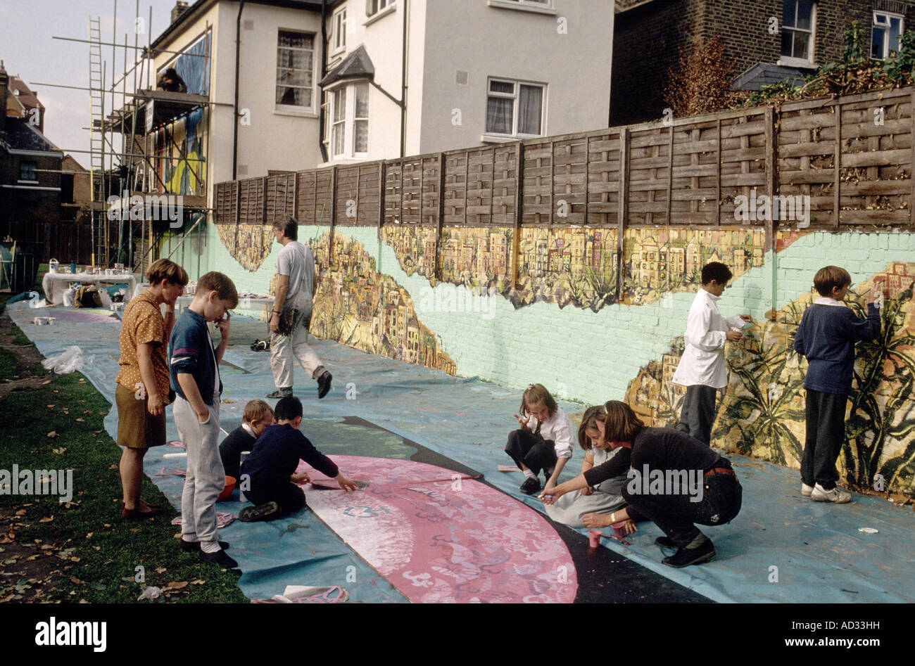 Young children painting a mural on the wall of a community park Stock ...