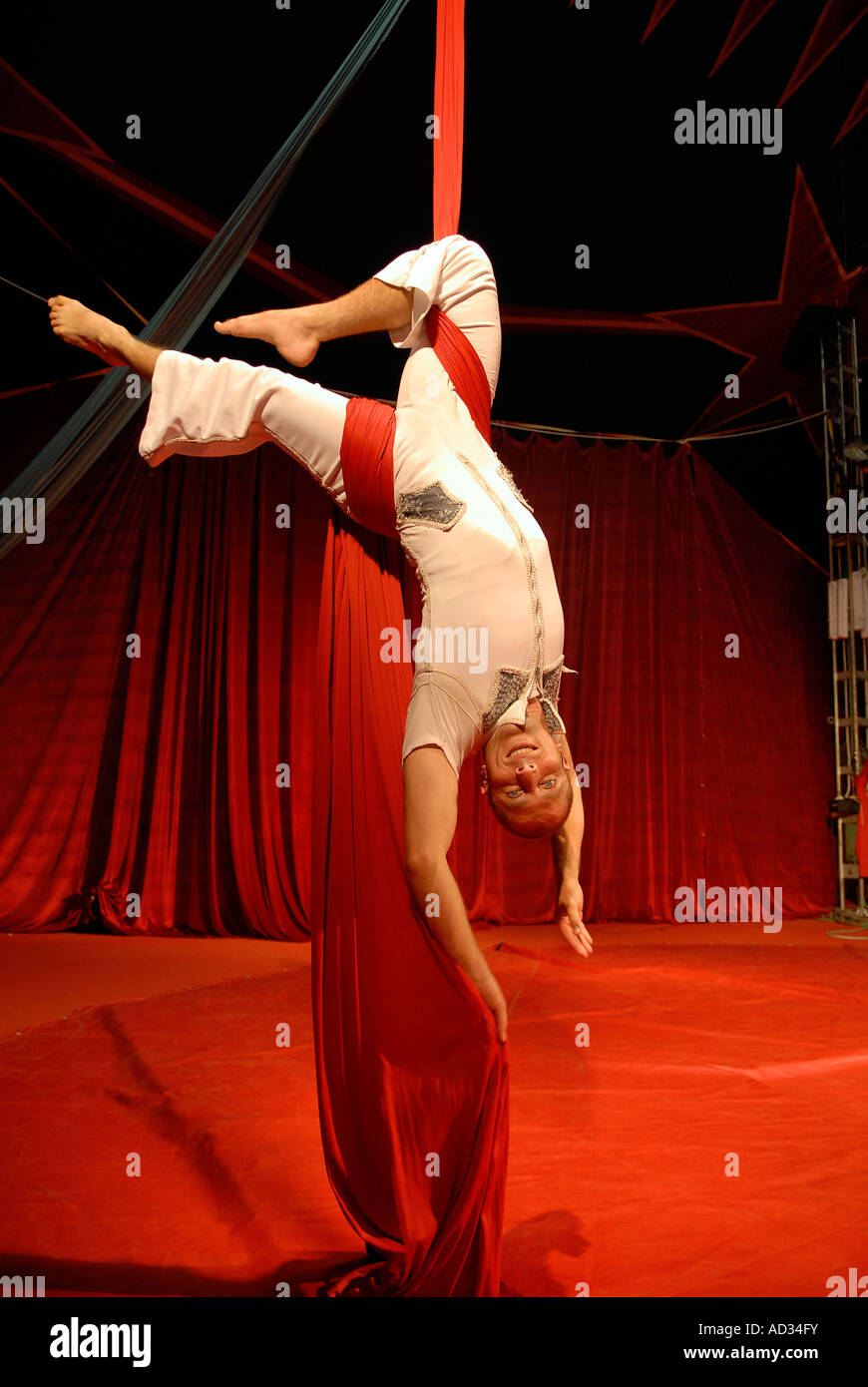 Circus acrobat performer tangled in red drapes Stock Photo - Alamy