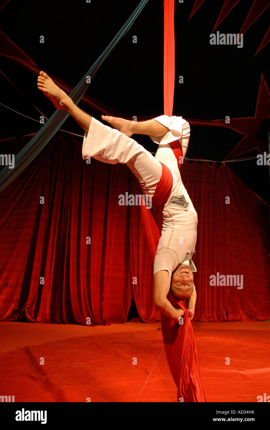 Circus acrobat performer tangled in red drapes Stock Photo - Alamy